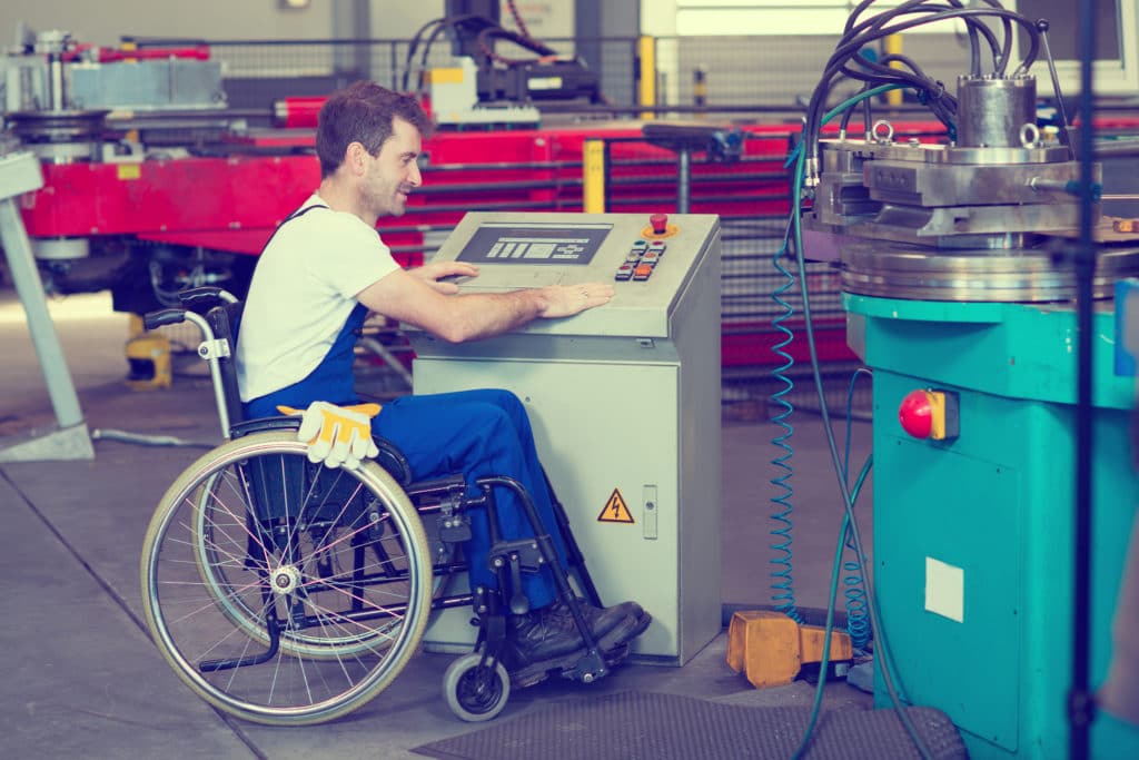 disabled worker in wheelchair in factory on the machine - CRFH